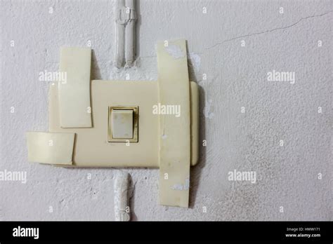 Dirty Broken Electrical Socket With Tapes On Usable Light Switch And The Small Long Crack White