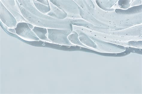 회색 배경에 얼굴에 히알루론산이 함유 된 투명한 세럼 젤 산소 거품이있는 화장품의 질감 웰빙과 아름다움 개념 개념에 대한 스톡