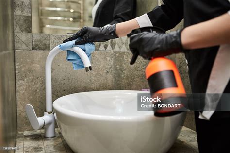 욕실에 있는 파란 걸레와 세제 살포를 가진 물 수돗물과 싱크대의 고무 장갑에 있는 직업적인 청소 서비스 회사 직원 20 24세에 대한 스톡 사진 및 기타 이미지 Istock
