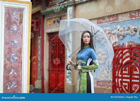 Vietnamese Women Wear Ao Dai Holding Umbrella In The Rain Stock Image