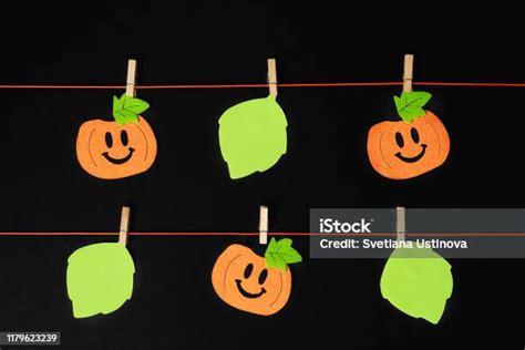 할로윈 테마 장식의 배경입니다 검은 색 배경에 나무 옷핀이 달린 끈에 매달려있는 장난감 호박 플랫 레이 스타일입니다 공간을 복사합니다 10월에 대한 스톡 사진 및 기타