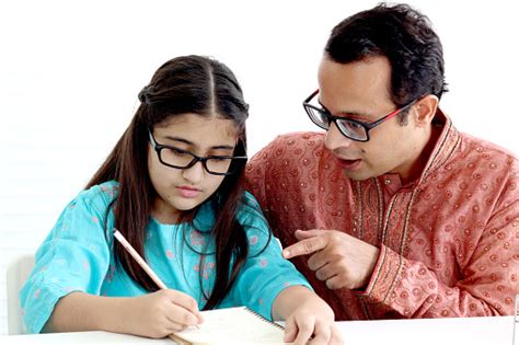 전통 의상과 안경을 쓴 귀여운 인도 여학생은 아버지와 숙제를 하고 아버지는 집에서 딸 아이를 가르치고 부모는 가정의 어린 시절 교육에 교사 교사가 된다 2명에 대한 스톡