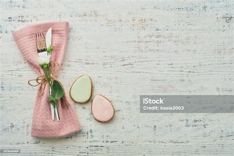 부활절 브런치 테이블 설정 봄 부활절 휴가 개념에는 흰색 분홍색 접시 냅킨이 있으며 장식 기호가 있는 휴일 토끼 계란 오래된
