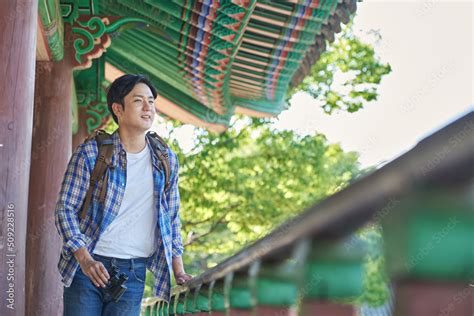 Fotografia Do Stock 한국의 옛날 전통 가옥의 처마 밑에서 여행하며 쌍안경으로 풍경을 관찰 또는 감상하는 아시아 한국 남자 모델 Adobe Stock