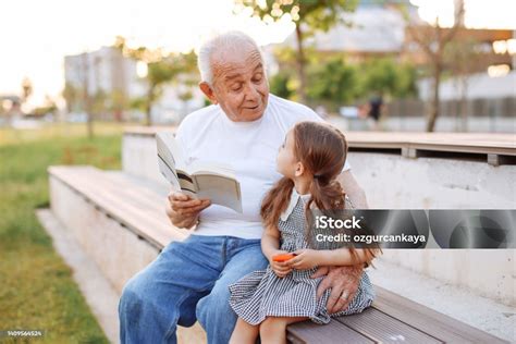 Kakek Membacakan Cerita Untuk Cucu Kecilnya Di Alam Foto Stok Unduh