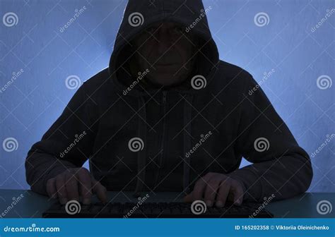 Hacker Wearing Hoodie Using Dask Keyboard To Crack Computer Blue