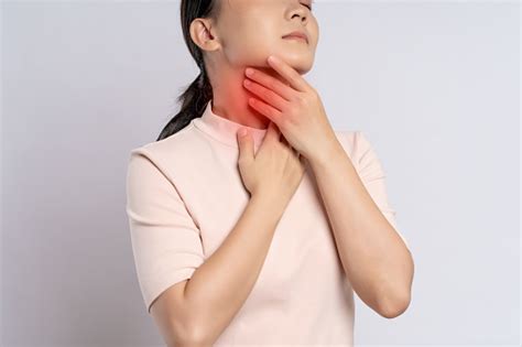 아시아 여성은 목이 아프고 목에 붉은 반점이 생겨 흰색 배경에 고립되어 서 있었다 A형 인플루엔자 바이러스에 대한 스톡 사진 및