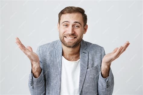 Красивый невежественный мужчина пожимает плечами не сознавая