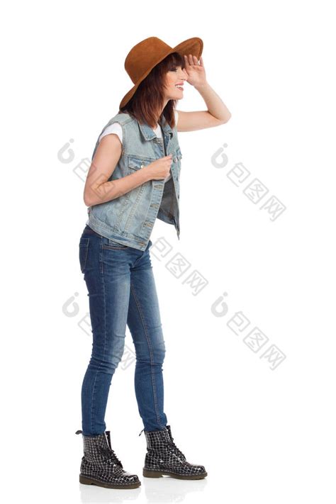 微笑的年轻女士在麂皮绒看着棕色的帽子图片 包图网企业站