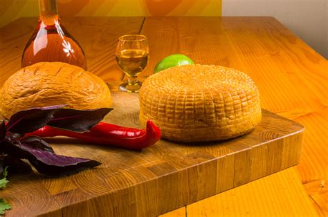 내셔널 Adyghe 치즈는 칼 바 질 파 슬 리 라임 참기름 칠리 페 퍼 마 카 다미아 너트와 나무 테이블에 디 켄 터와 함께 커팅 보드에 클로즈업 갈색에 대한 스톡 사진