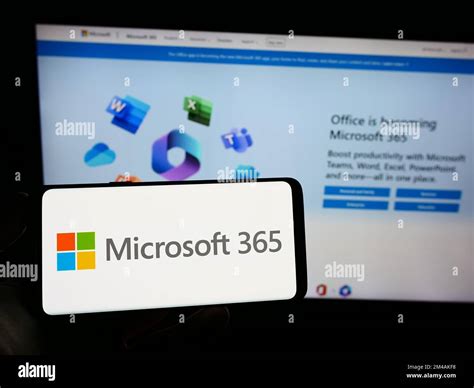 Person Holding Smartphone With Logo Of Productivity Software Microsoft 365 On Screen In Front Of