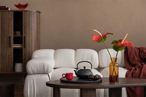 부르고뉴 색상의 모형 포스터 프레임 예술 부클 소파 세련된 커피 테이블 패턴 러그 대리석 램프 꽃 및 개인 액세서리로 거실 인테리어의 따뜻하고 아늑한 가을 구성 가정 장식