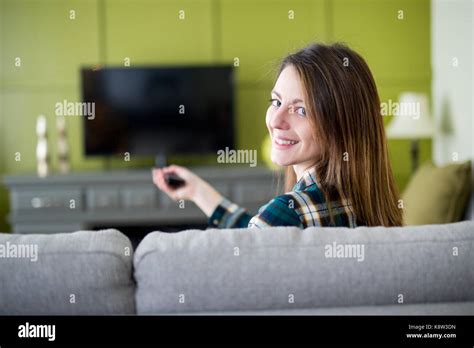 Beautiful Woman Watching TV Sitting On Couch At Home Stock Photo Alamy
