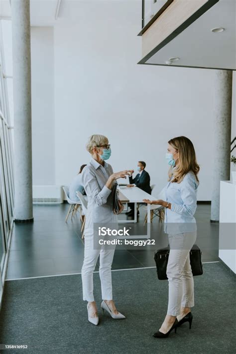 사무실에서 말하고 바이러스 보호로 마스크를 착용하는 두 명의 사업가 30 34세에 대한 스톡 사진 및 기타 이미지 30 34세 45 49세 55 59세 Istock