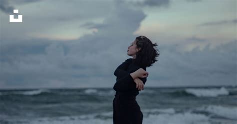 Uma Mulher Em Pé No Topo De Uma Praia Ao Lado Do Oceano Foto Imagem