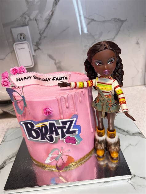 A Birthday Cake That Looks Like A Bratz Doll Is On A Table With Marble Countertop