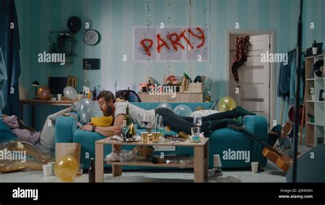 Bearded Guy Waking Up And Sitting Down On Couch Then Touching Face Covered With Confetti And