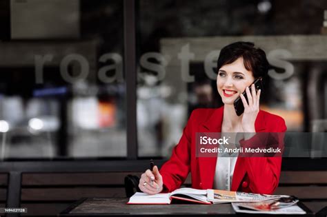 스마트폰으로 이야기하는 웃는 여성 사업가들 도시 테라스에 있는 카페에서 메모를 하고 있다 원격의 고객과의 사무원 통신 커피 브레이크 비즈니스 컨셉 30 34세에 대한 스톡