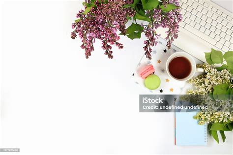 현대 여성의 바탕 화면 홈 오피스 라일락 꽃이있는 가벼운 테이블에 꽃 차와 쿠키 한 잔 재료와 건강 한 아침 식사 건강 한