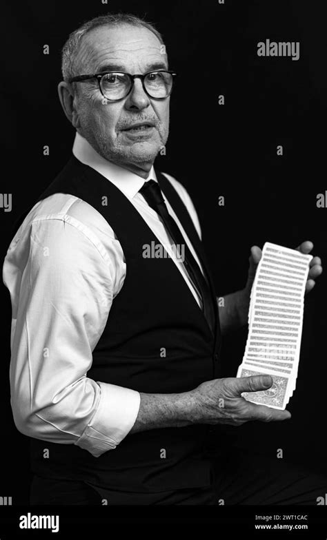 A Magician Manipulates Playing Cards To Perform A Magic Trick Dressed