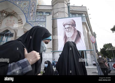 Iranian Veiled Women Walk Past A Portrait Of Irans Supreme Leader