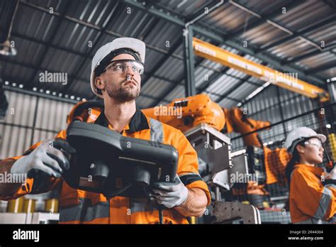 Engineer Team Working With Robot Welding In Automation Factory People Worker In Safety Suit