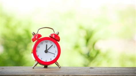 Red Alarm Clock With Green Nature Background Time To Relax At 12 O
