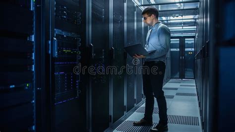 In Data Center It Engineer Stands Before Working Server Rack Doing