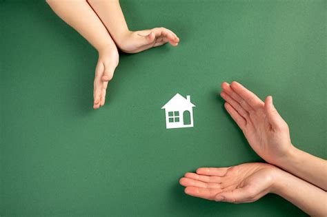 가족 주택 및 부동산 개념 녹색 배경에 흰색 종이 집과 마음을 들고 여성과 어린이 손을 닫습니다 플랫 레이 복사 공간 가족에