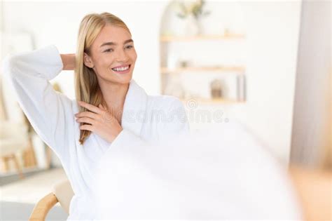 Blonde Lady Touching Long Hair Caring For Herself In Bathroom Stock