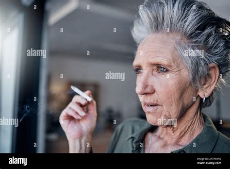 Thinking Nicotine And A Senior Woman Smoking A Cigarette In Her Home