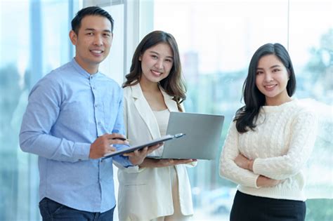 일에 전념하는 젊은 아시아 사업가들의 만남 비즈니스 회의 팀으로서 다양한 작업의 세부 사항을 논의하고 사무실에 함께 앉으십시오