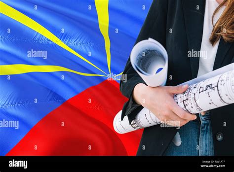 Architect Woman Holding Blueprint Against Reunion Waving Flag Background Construction And