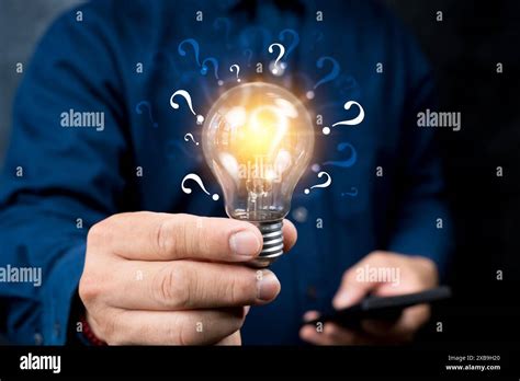 Businessman Holding Glowing Lightbulb And Question Mark With Copy Space For Creative Thinking