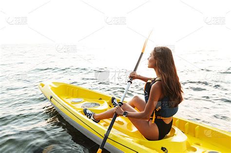 美丽的女人在湖上划船。