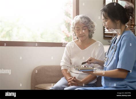 Healthcare Worker Or Caregiver Visiting Senior Woman Indoors At Home