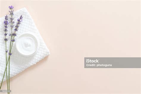 파스텔 핑크 배경에 보습 바디 크림 목욕 수건 라벤더 꽃 항아리 스킨 케어 화장품 컨셉 최소한의 플랫 레이 스타일 컴포지션 상단