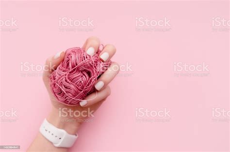 밝은 분홍색 배경에 섬세한 흰색 유백색 매니큐어를 가진 젊은 여성의 손 피부 관리 및 손톱 치료 미용 절차 손톱 젤 개념에 대한