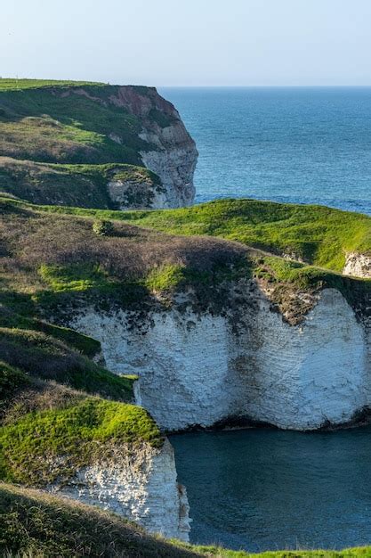 Premium Photo A Cliff With A Green Grass And A White Cliff With A