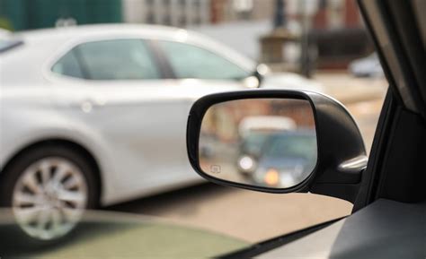 El espejo retrovisor del automóvil refleja una carretera escénica detrás el espejo simboliza el
