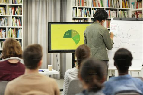 화이트보드 근처에 서서 전략을 작성하고 프레젠테이션 중에 사람들에게 설명하는 청년의 뒷모습 사진 Unsplash의 세미나 이미지