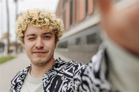 Handsome Young Caucasian Guy Wears In Casual Clothes Winks At Camera