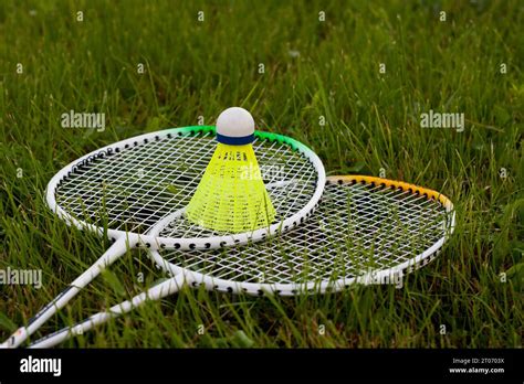 Badminton Set Yellow Shuttlecock And Rackets Lying On Green Grass