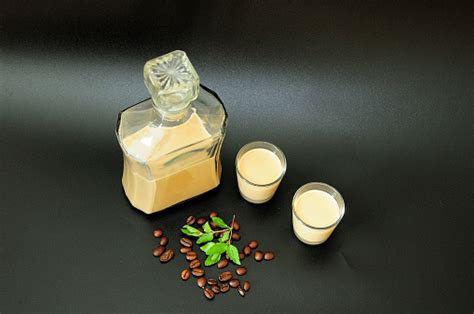 크리미한 커피 리큐어 병에 담긴 수제 알코올 검은 배경에 두 잔 민트 잎과 커피 원두 옆 0명에 대한 스톡 사진 및 기타 이미지