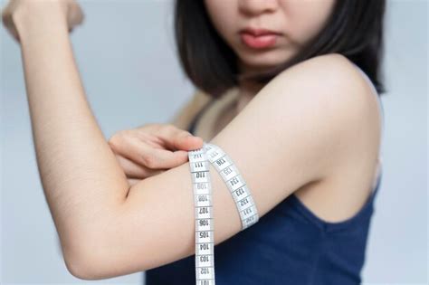 Premium Photo A Woman Measuring The Proportions Of Her Upper Arm With A Tape Measure After