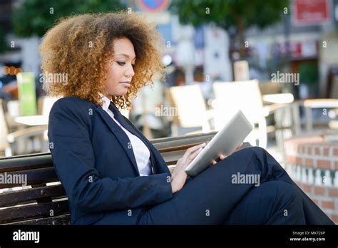 Beautiful Black Woman Using Tablet Computer In Urban Background