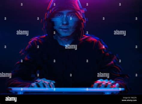 hacker in the hood working with computer typing text in dark room