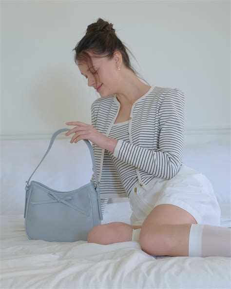 탈리 Talli New Cozy Pring Bag 리본과 메탈 로고 장식이 포인트로 들어있어 앞 뒤 모두 매력적으로 착용 가능한 숄더백 입니다 숄더끈과