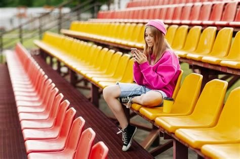 Premium Photo A Teenage Girl Sits On The School Bleachers And Writes