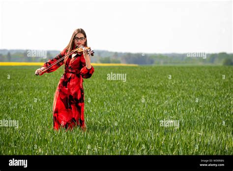 Femme Musicienne En Robe Rouge Jouant Du Violon Banque De Photographies